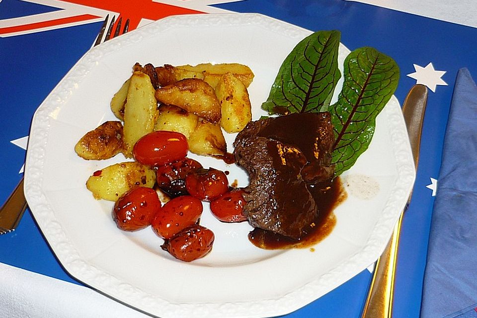 Kangaroo fillet with plum sauce, braised cherry tomatoes and potato ...